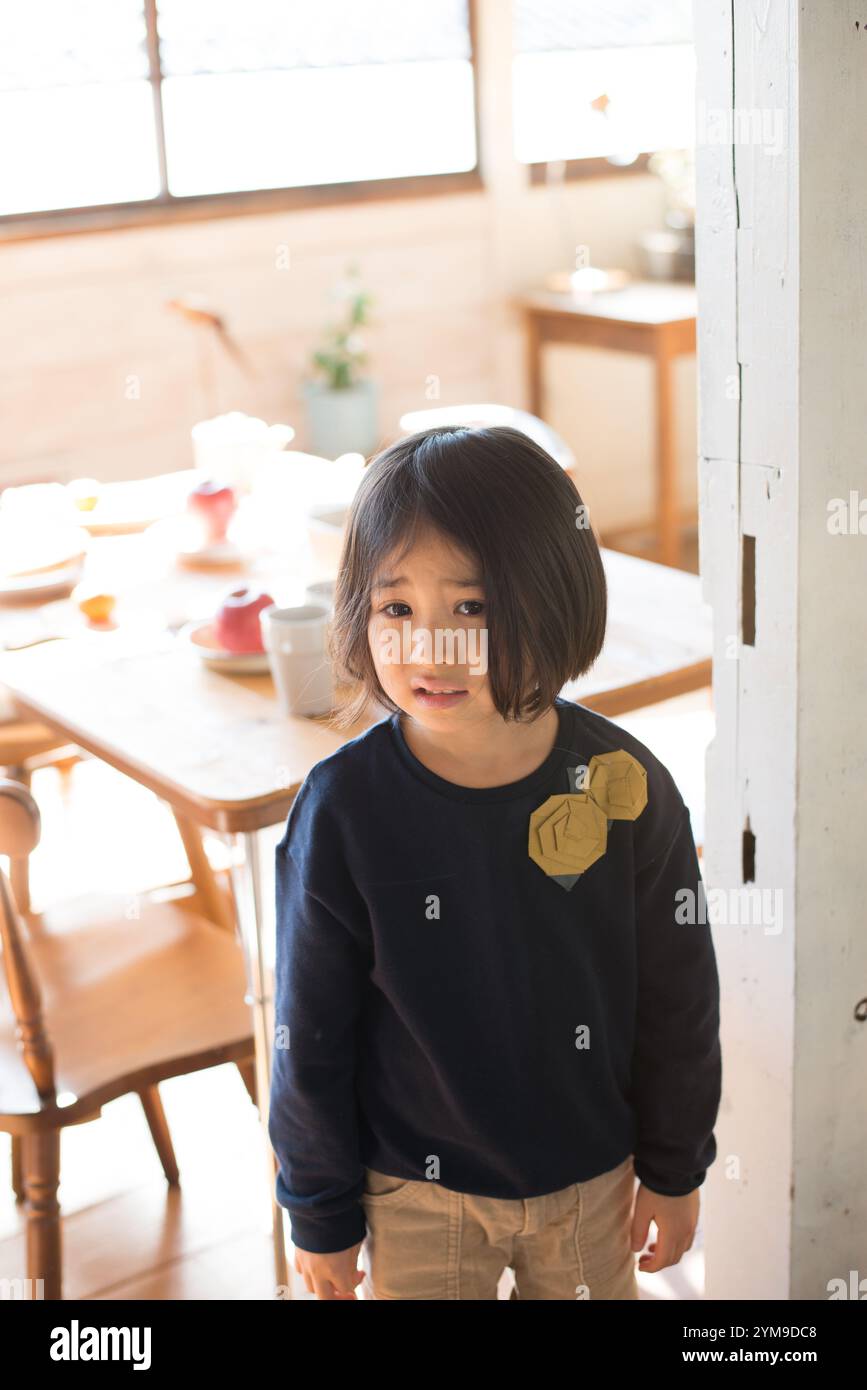 Child standing in front of table Stock Photo - Alamy