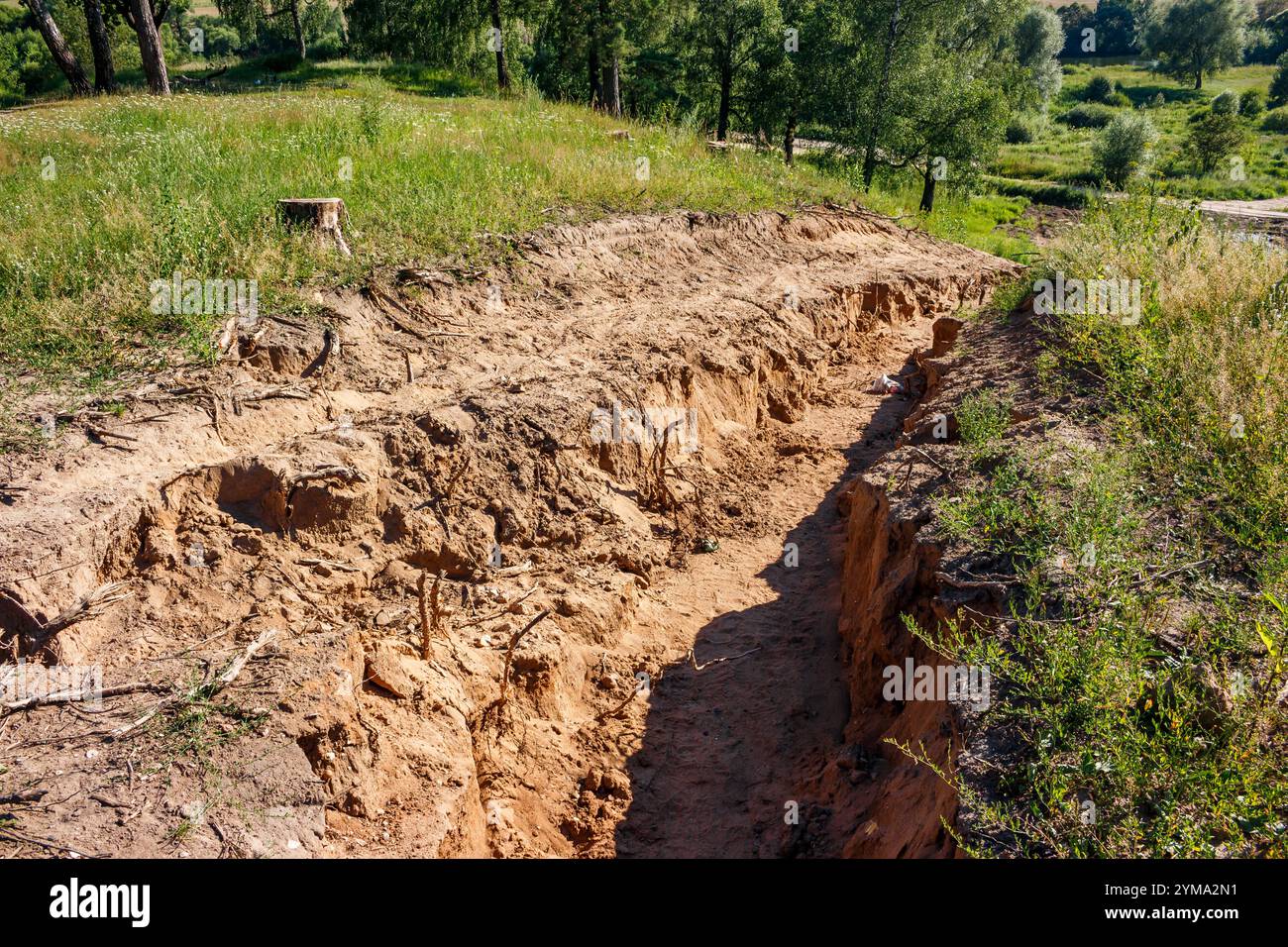 Gully in the ground on a slope, ravine formation in sandy soil, rain ...