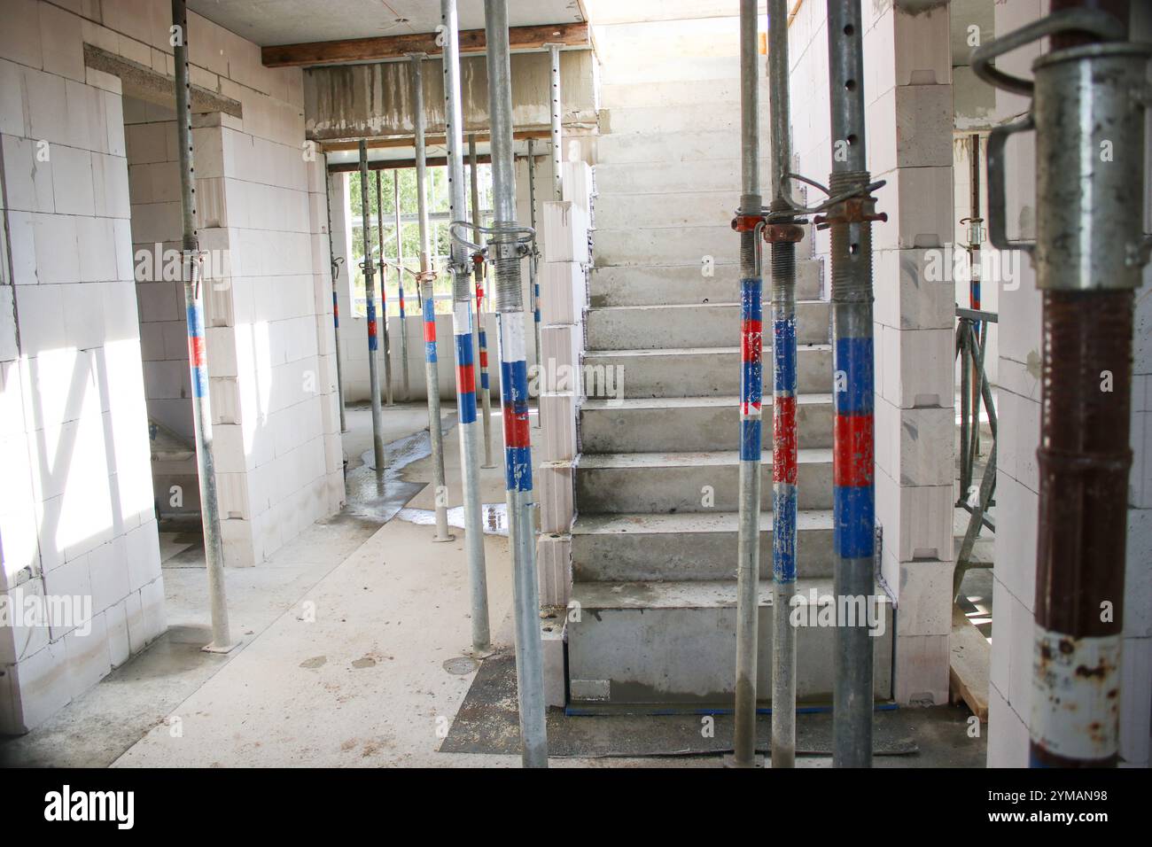 Inside view of a new building with concrete stairs and support beams ...