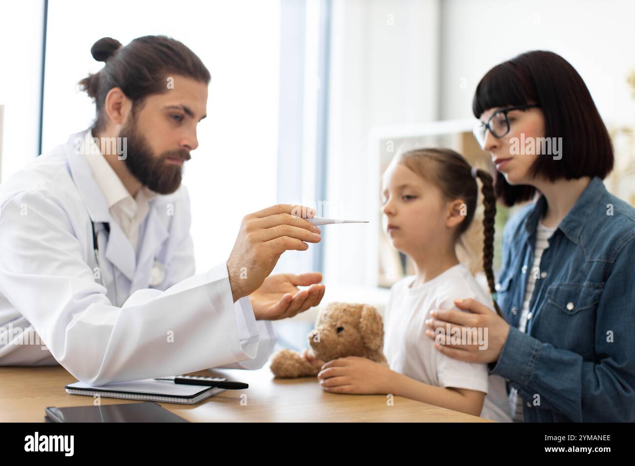 Doctor taking temperature of young girl in medical office Stock Photo - Alamy