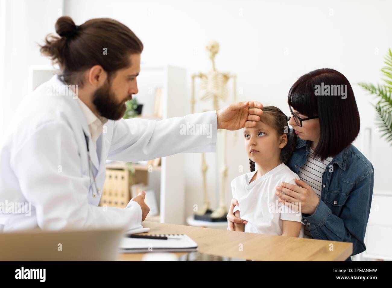 Doctor checking temperature of sick child with concerned mother Stock ...