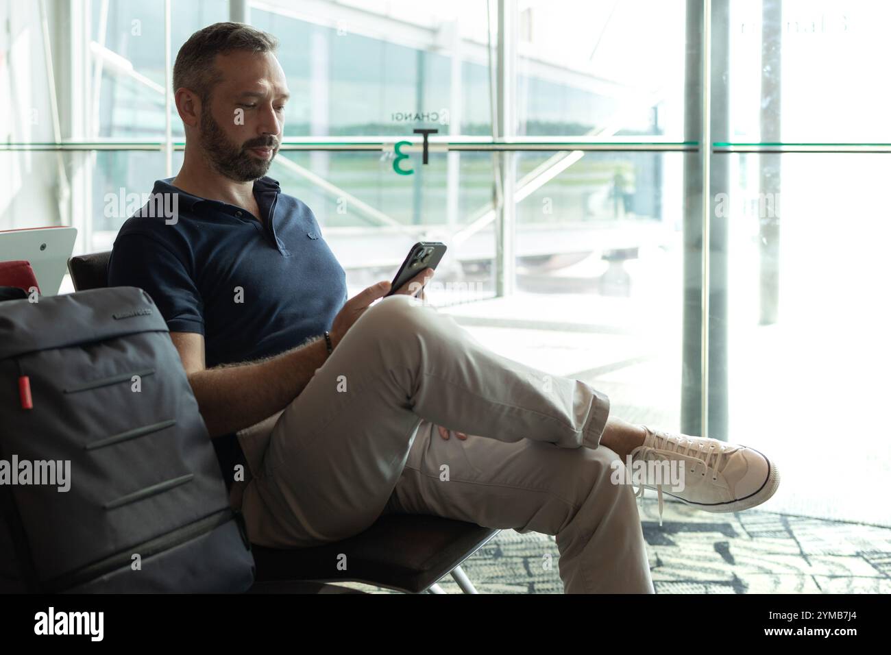 Man sitting and scrolling phone in a waiting room in the airport Stock ...