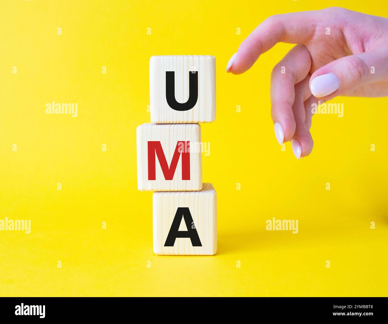 UMA - Unified Managed Account. Wooden cubes with word UMA. Businessman ...