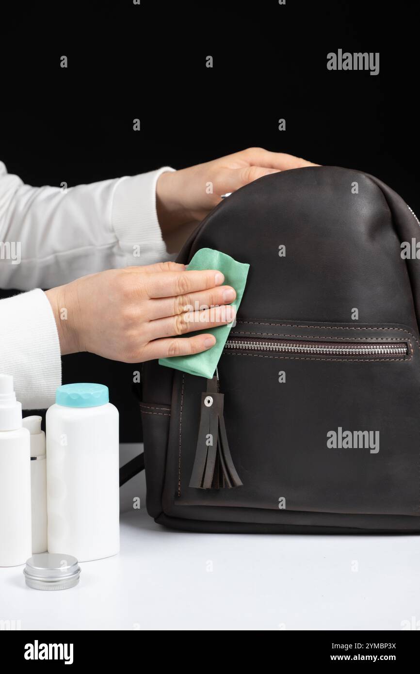 Cleaning the surface of a leather backpack with a cloth. Caring for ...