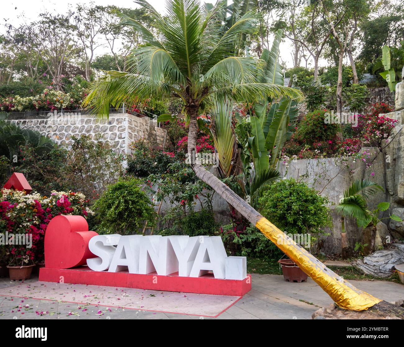 A white sign spelling Sanya with a red heart to its left is on display ...