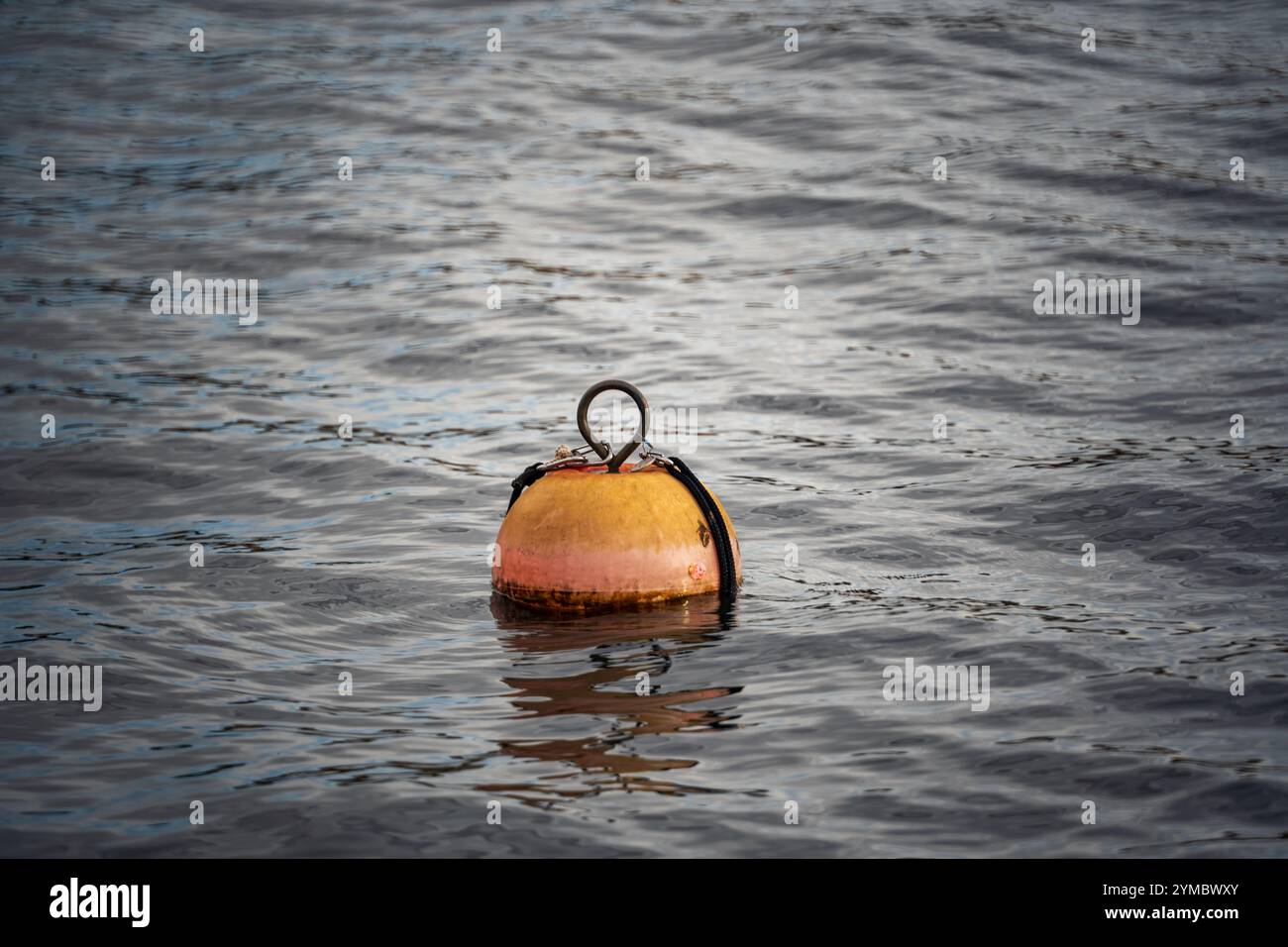 Orange, round buoy floating on a lake water. Close up shot, no people ...