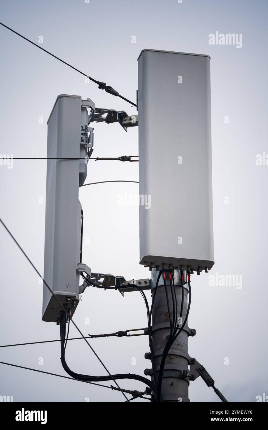 5G cell tower with signal repeaters. Close up shot, low angle, no ...