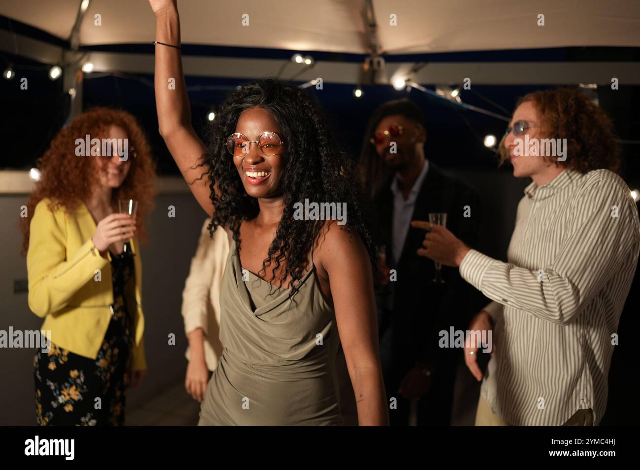 Cheerful multiethnic friends enjoying rooftop party, dancing and ...