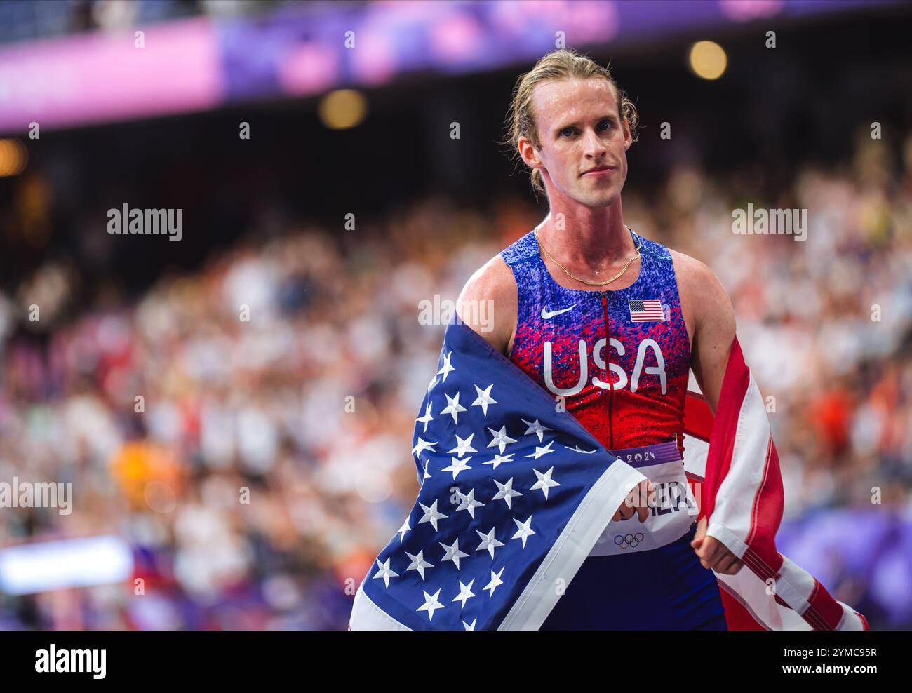 Cole Hocker celebrating her medal with her country's flag at the Paris ...