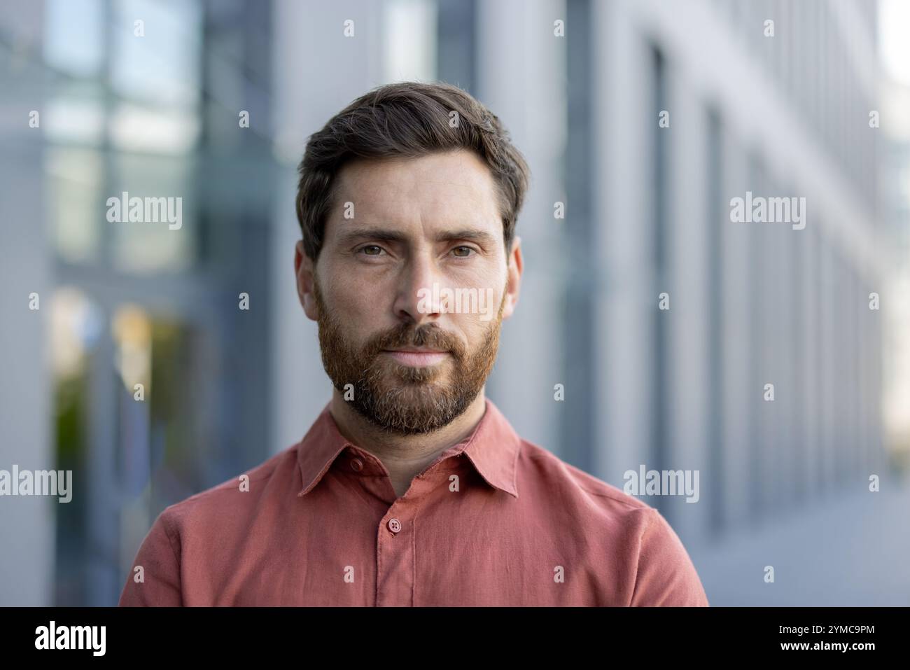 Mature businessman outdoors in an urban area, wearing smart casual ...