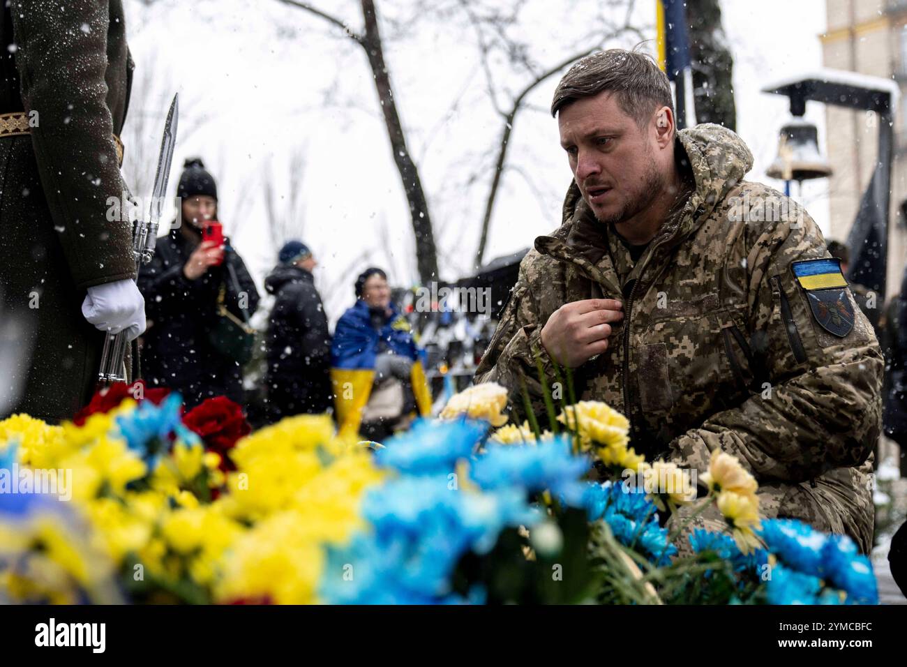 Ukrainian soldier laying flowers, honoring fallen fighters at ...