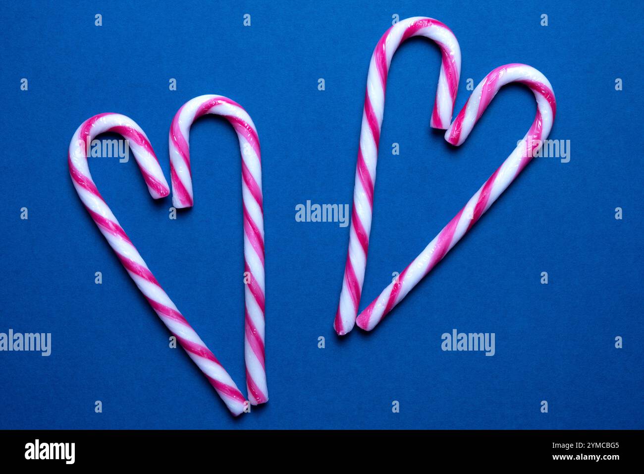 Two candy canes arranged in heart shapes showcase festive colors ...