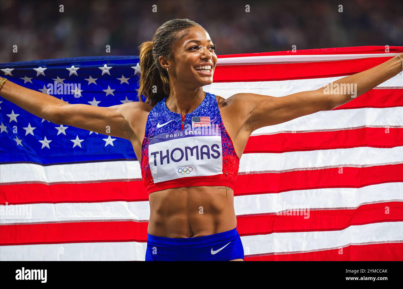 Gabrielle Thomas celebrating with her country's flag in the 200 meters ...