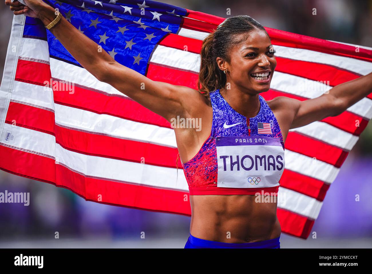 Gabrielle Thomas celebrating with her country's flag in the 200 meters ...