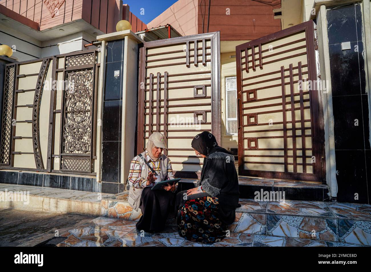 An Iraqi census researcher collects information from a woman in the ...