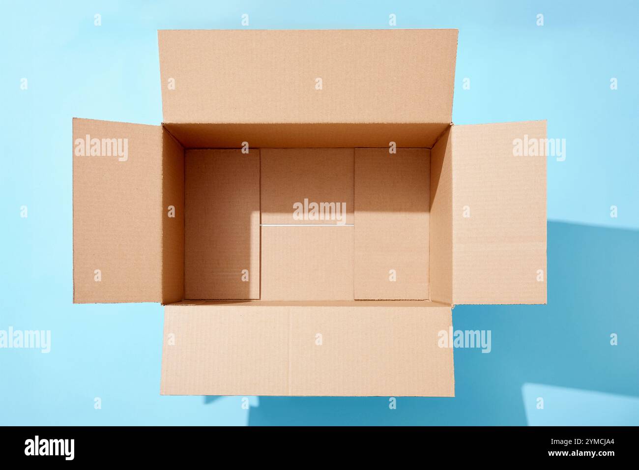 Overhead view of open empty cardboard box on blue background Stock ...