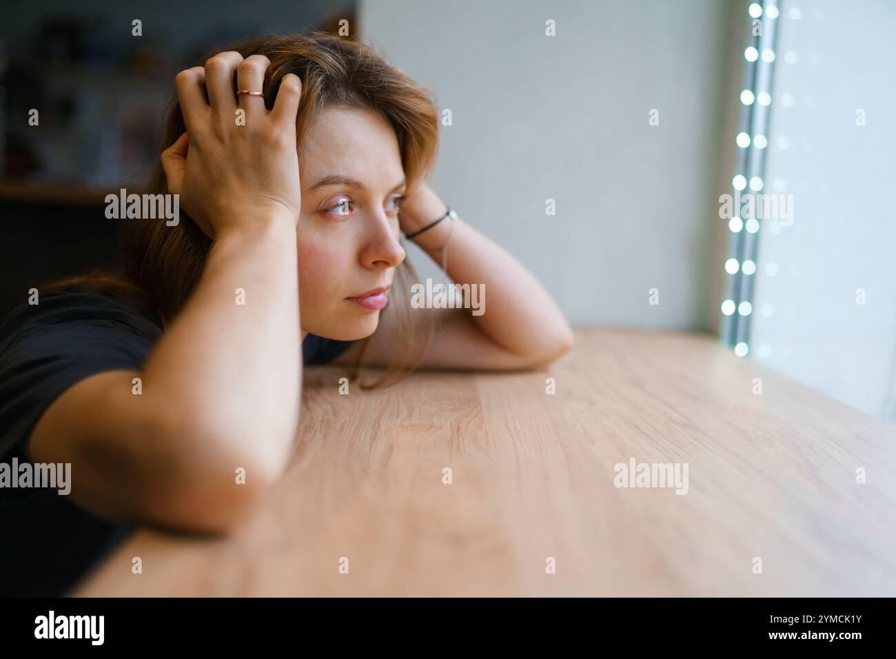 Woman leaning on window sill and looking through window Stock Photo - Alamy