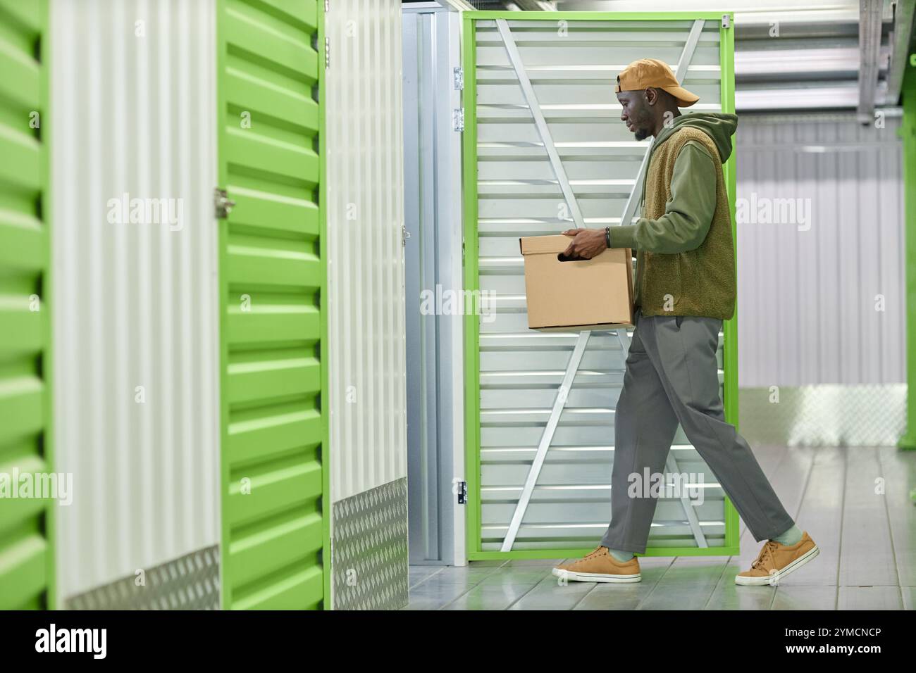 Side view of Black man carrying cardboard box filled with personal ...