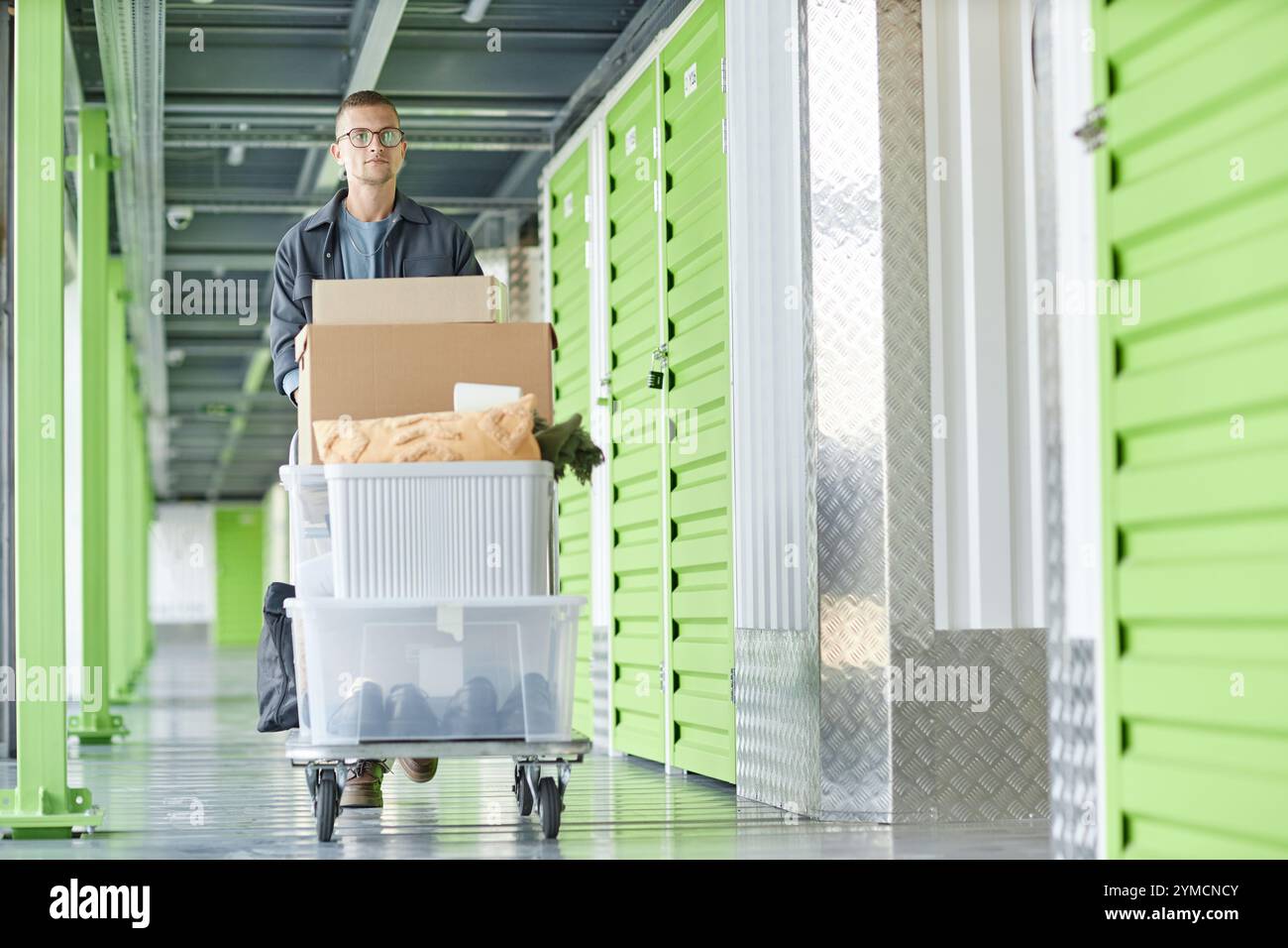 Full length shot of man pushing cart loaded with boxes full of home ...