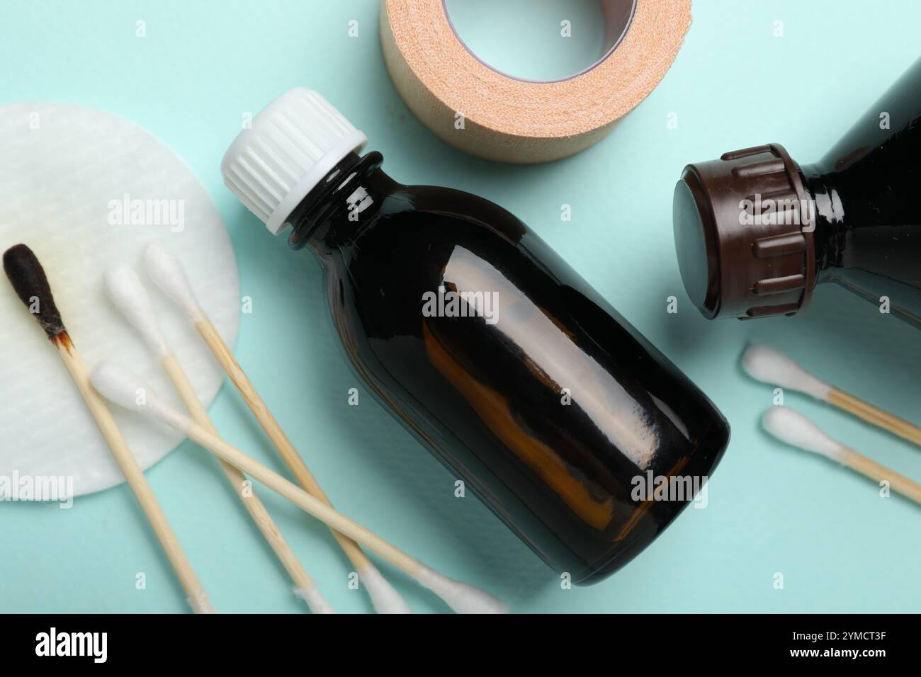 Topical iodine and other first aid kit components on light blue ...