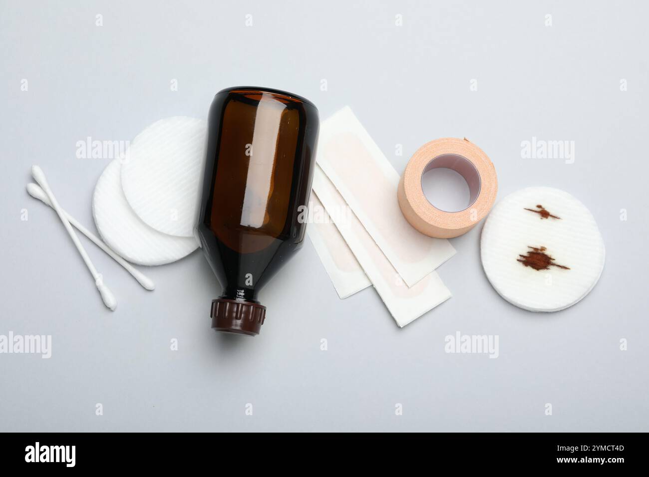 Topical iodine and other first aid kit components on light grey ...