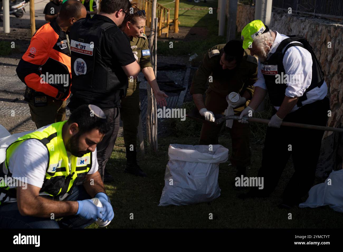 Members of ZAKA rescue services work at the site where a rocket fired ...