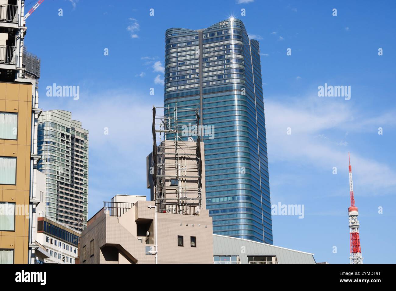 View of rooftops in Tokyo's Roppongi area with Tokyo Tower and Azabudai Hills Mori JP Tower ...