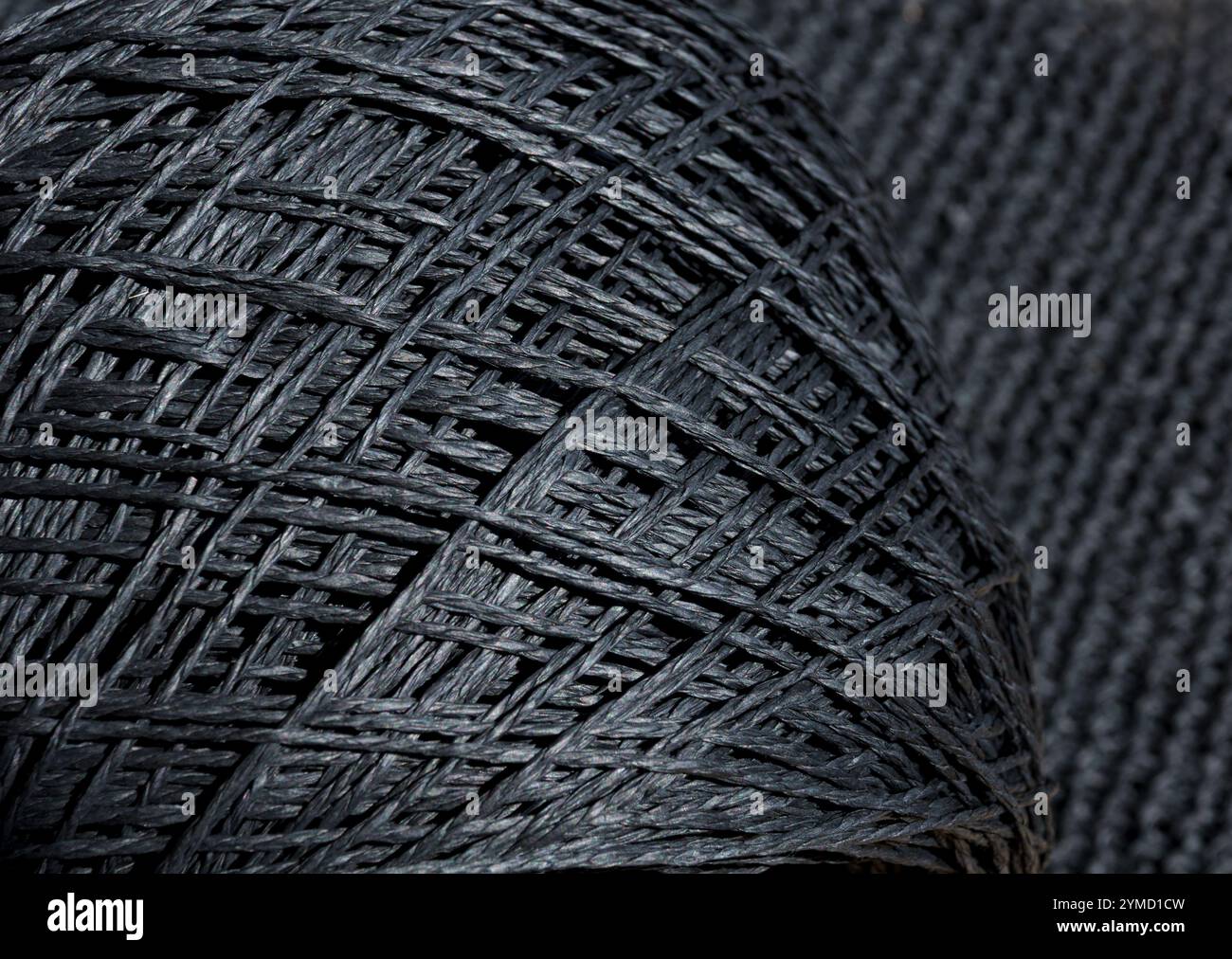 A skein of black raffia on a black background. Raffia is an eco ...