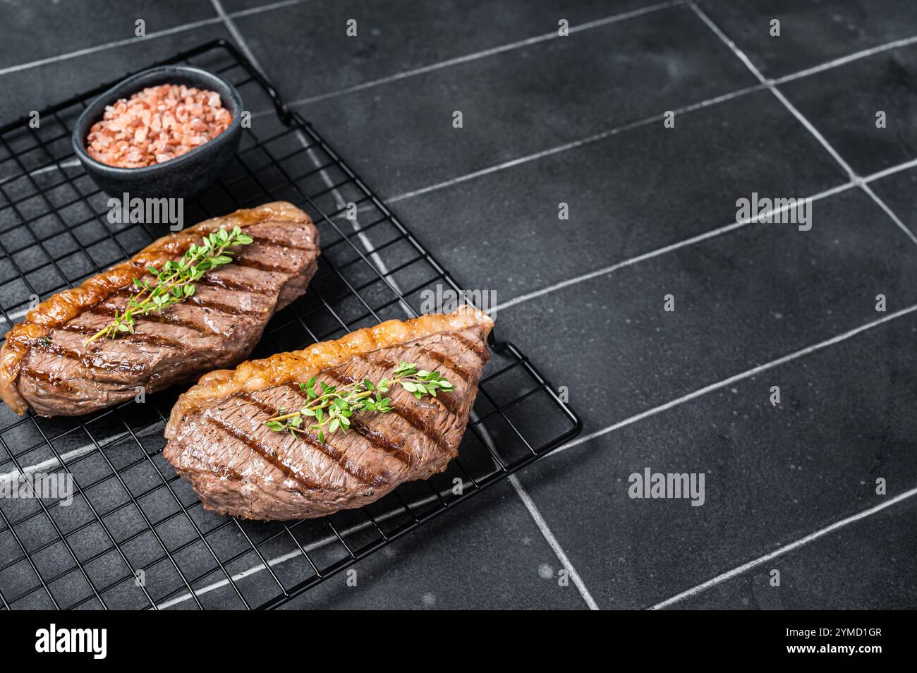 Grilled top sirloin or cup rump beef meat steak on a rack. Black ...