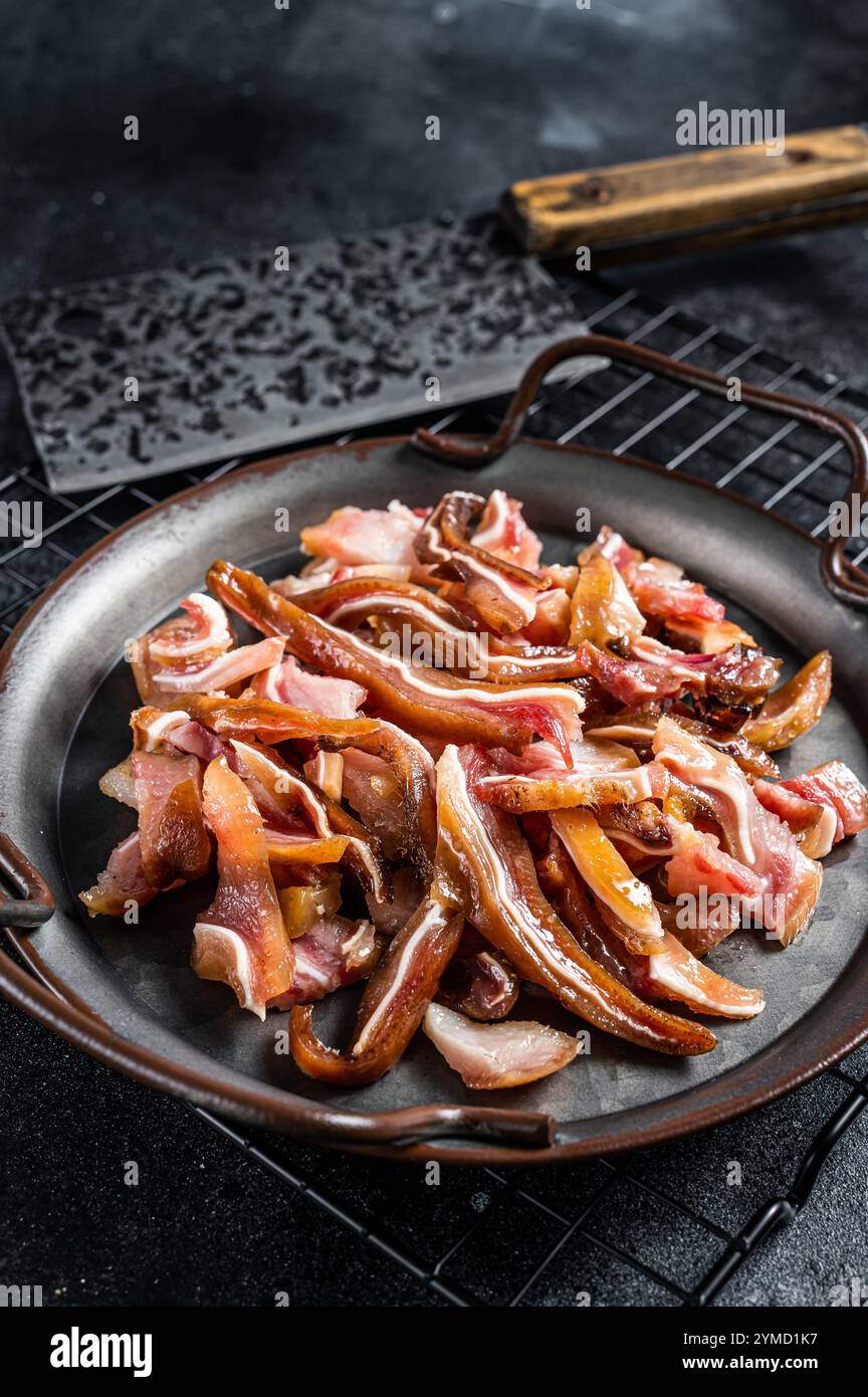 Traditional gourmet smoked pork pig ears. Black background. Top view ...