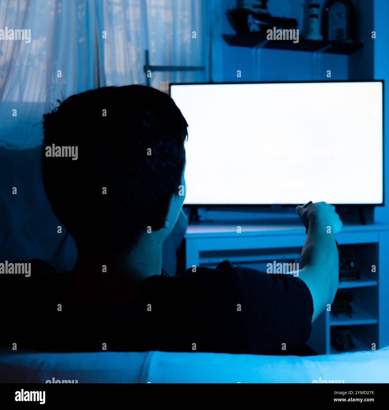 Man watching TV in his living room at night, concept of watching TV at ...