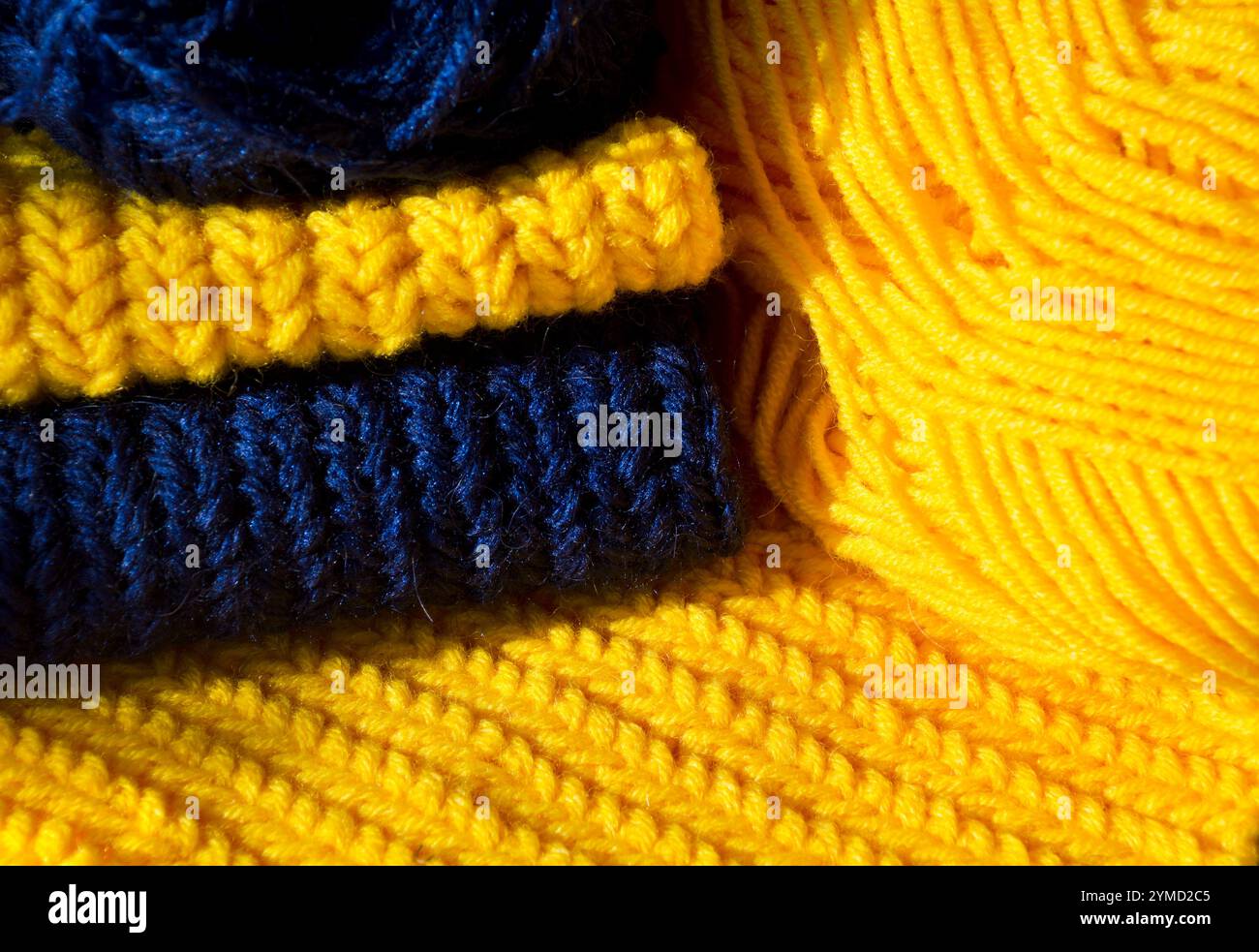 Texture of a crochet pattern made from yellow and blue wool yarn. Close ...