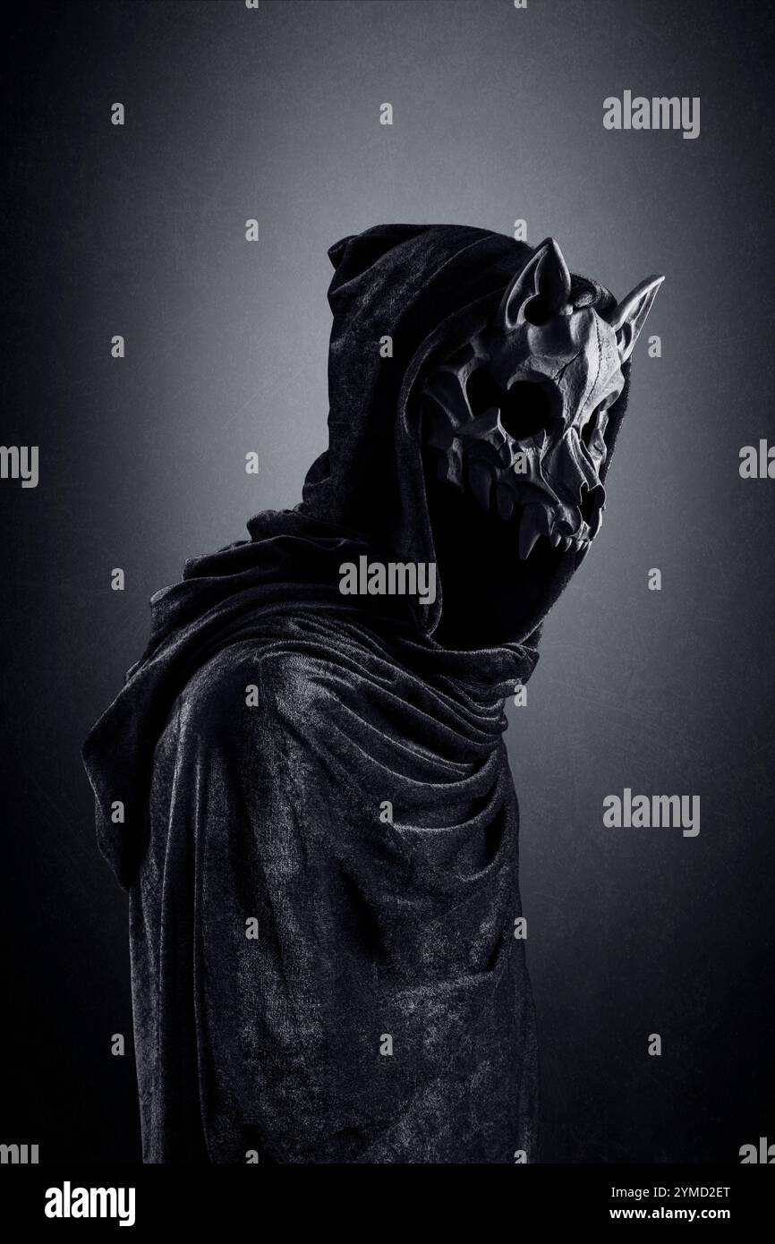 Creepy figure with animal skull at night over dark misty background ...