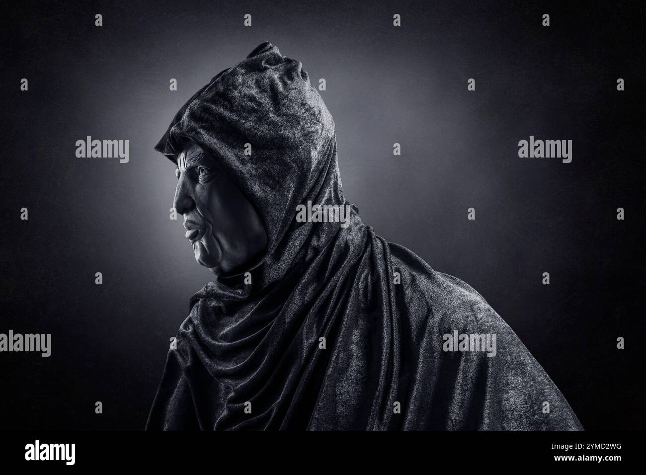 Scary figure with hooded cloak in the dark Stock Photo - Alamy