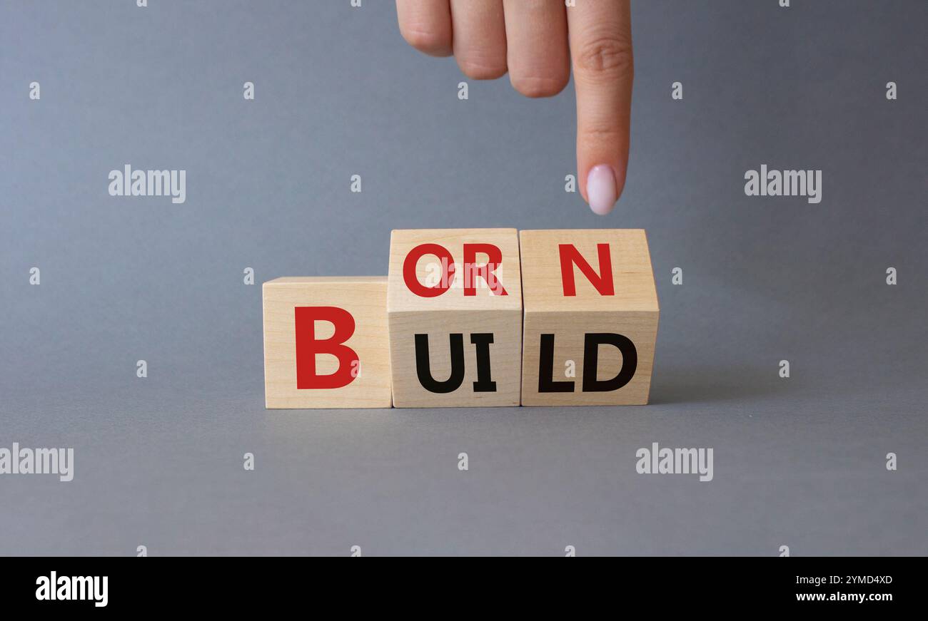 Born and Build symbol. Businessman hand points at turned wooden cubes ...