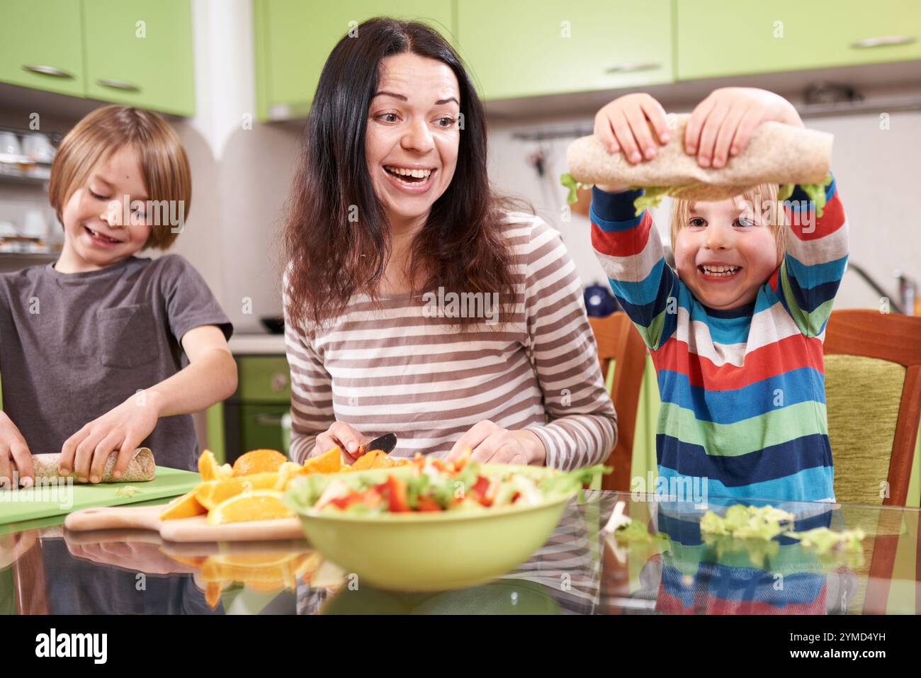 Happy family preparing healthy food in the kitchen, mother and children ...