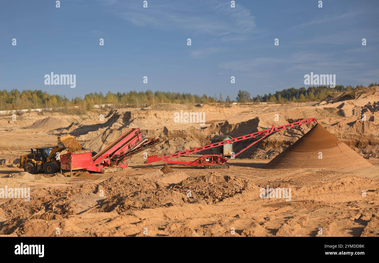 The heavy tractor works in a sand quarry. Quarry sand with a grinding ...