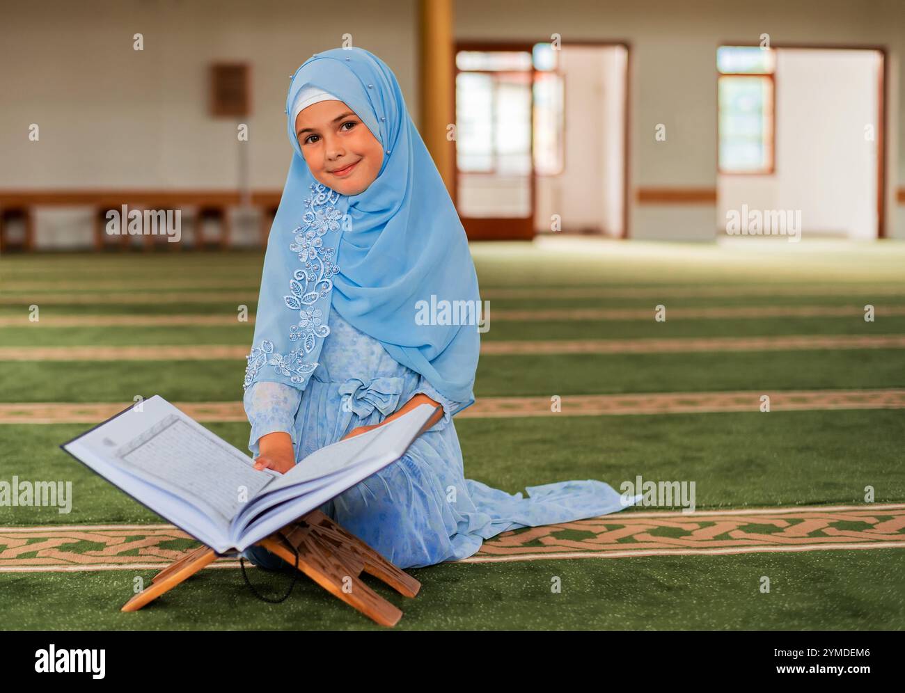 A Muslim child girl reading a Quran inside the mosque Stock Photo - Alamy