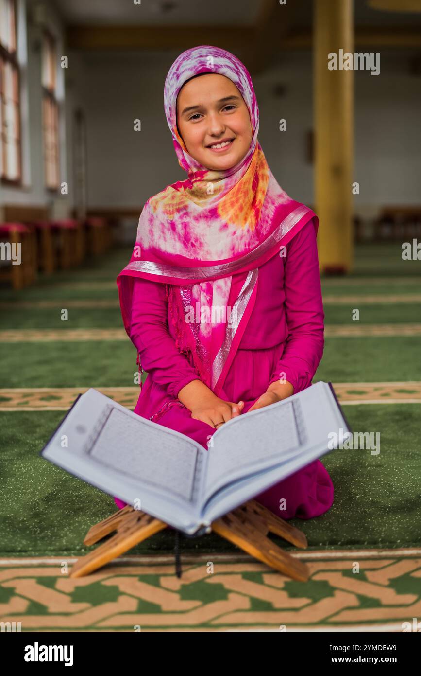A Muslim child girl reading a Quran inside the mosque Stock Photo - Alamy