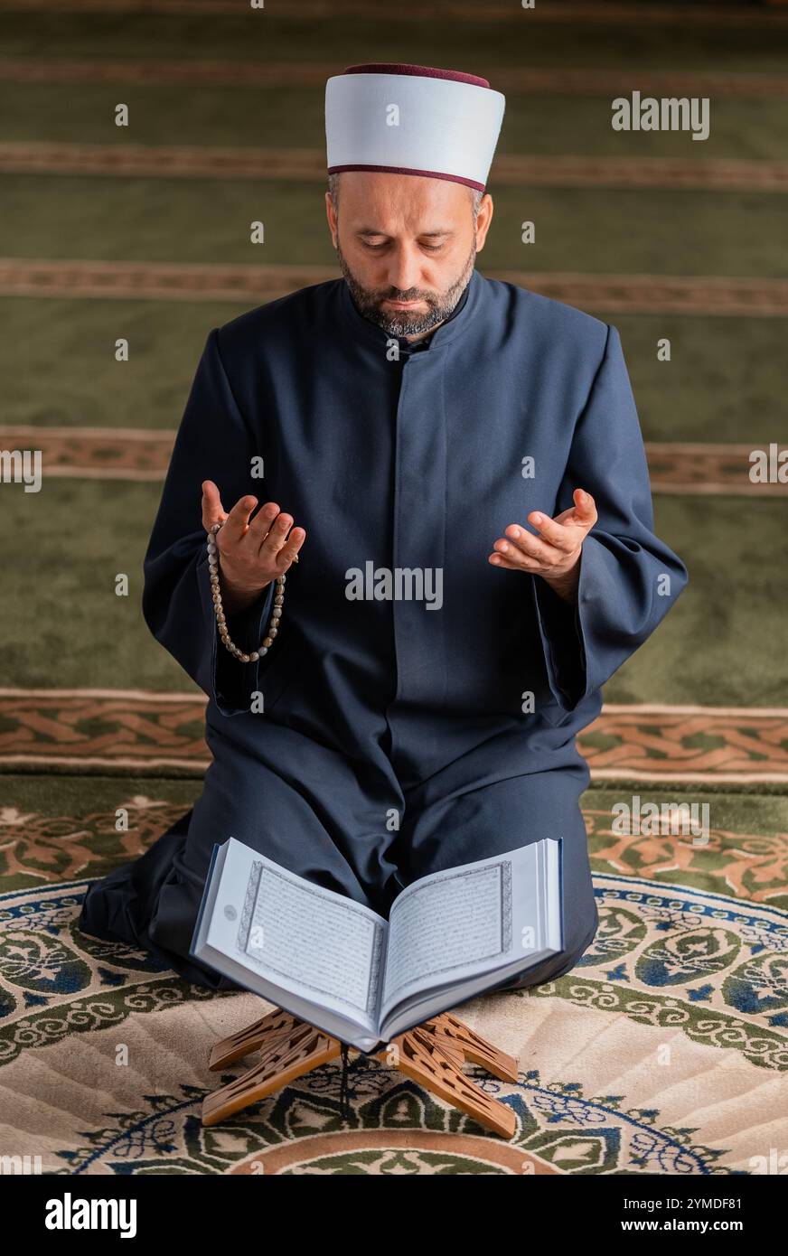 A Muslim prayer man praying with hands up inside the mosque Stock Photo ...