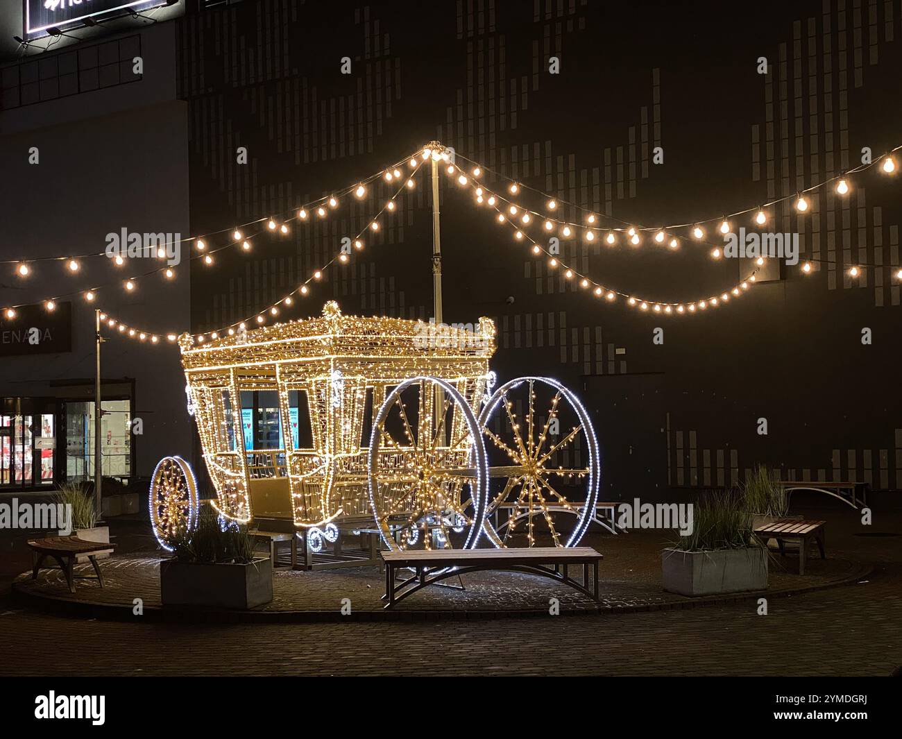 A carousel with lights on it. The carousel is in a parking lot. There ...