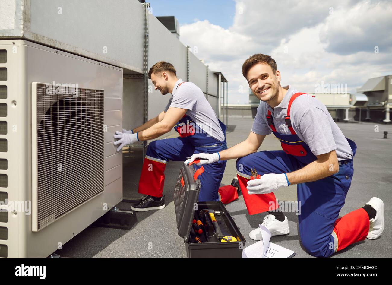 Smiling Electrician Installing HVAC System on Roof Stock Photo - Alamy