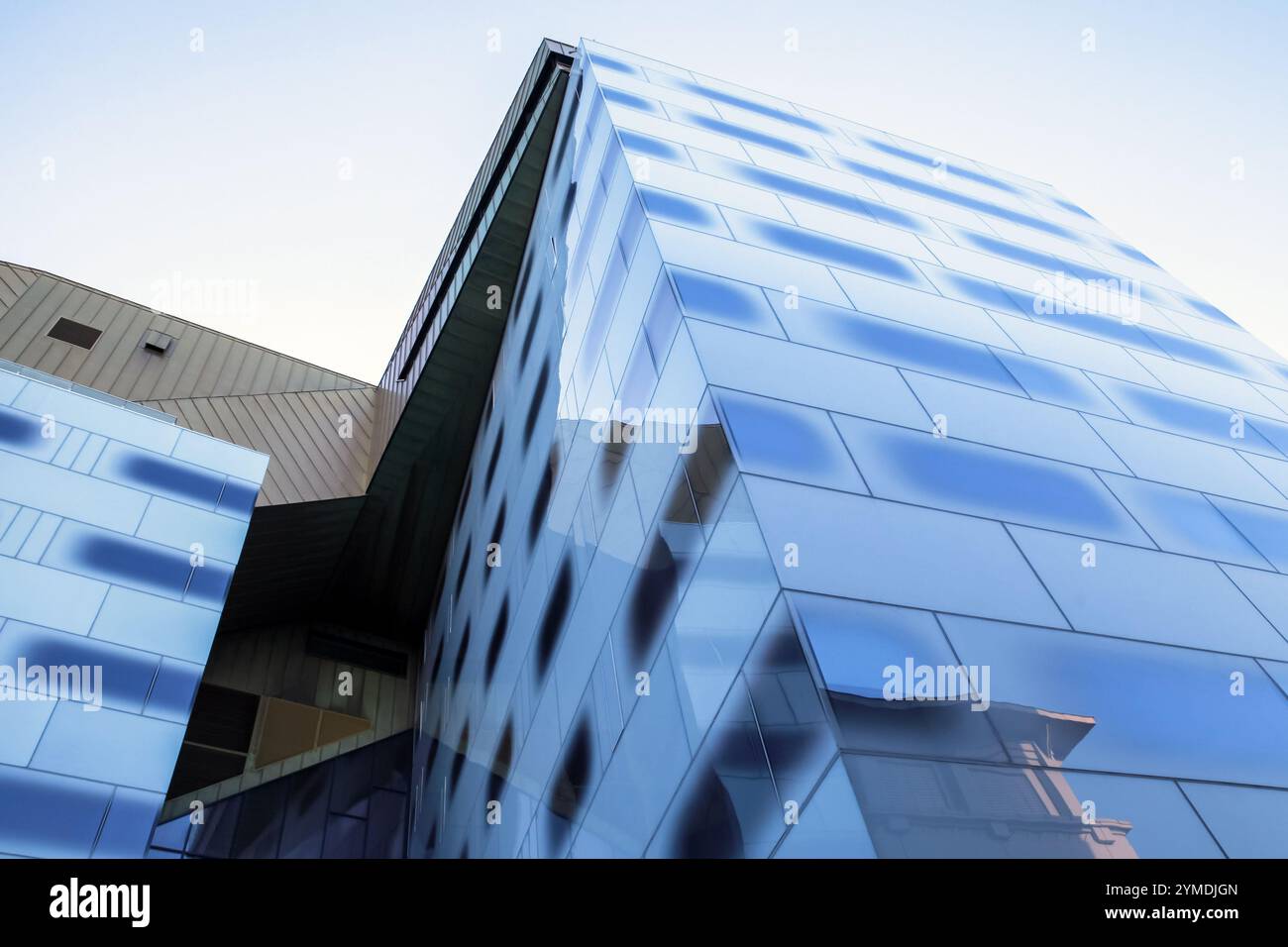 Contemporary architecture, shiny glass facade is under bright blue sky ...