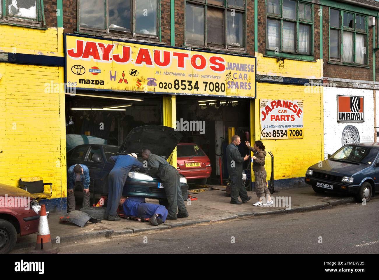 Men working outside a car repair garage. East London the Lower Lea ...