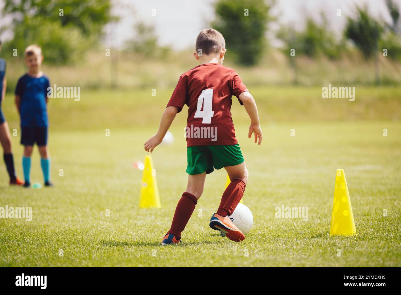 Boys attending soccer training on school field. Young man coaching ...