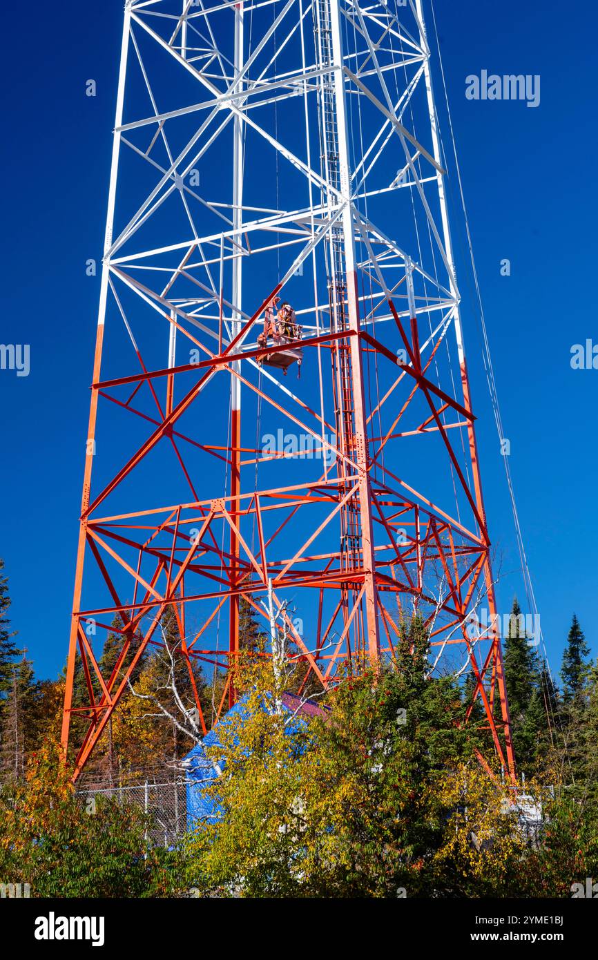A worker paints a communications tower at Palisade Head, a Lake ...