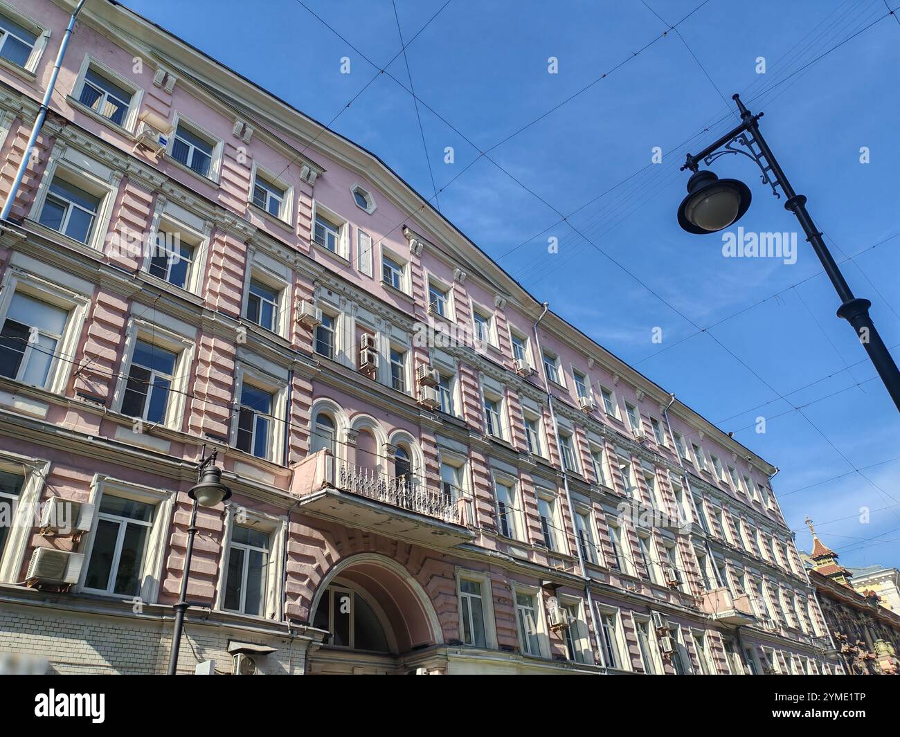 A three-story building with a pale yellow exterior and symmetrical ...