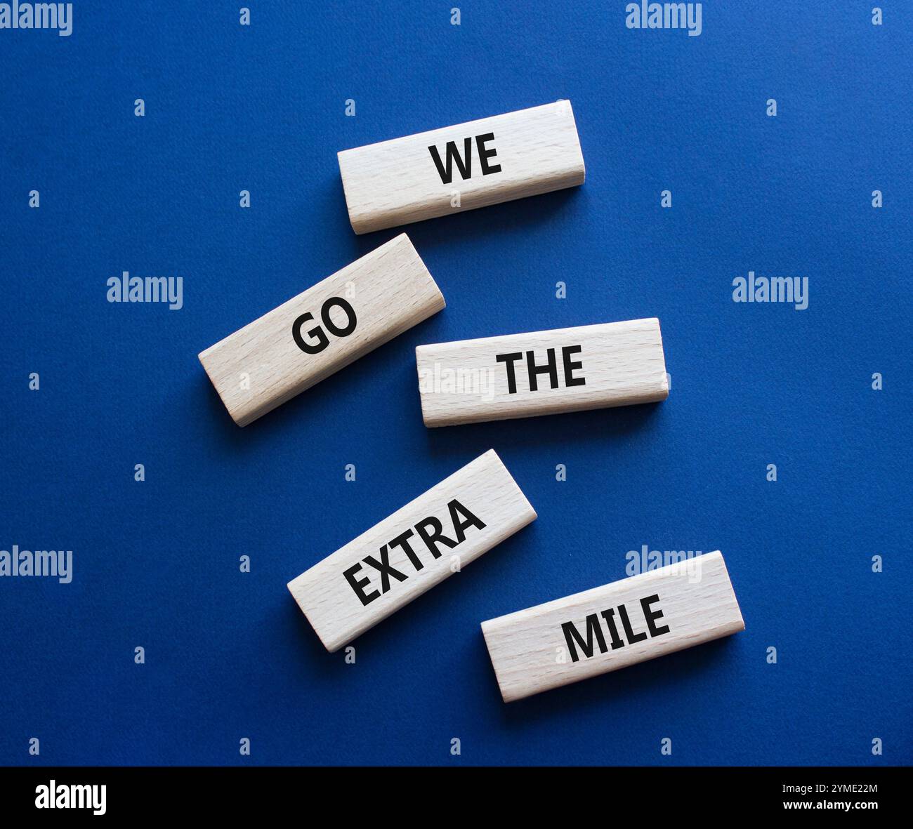 We go the extra mile symbol. Wooden blocks with words We go the extra ...