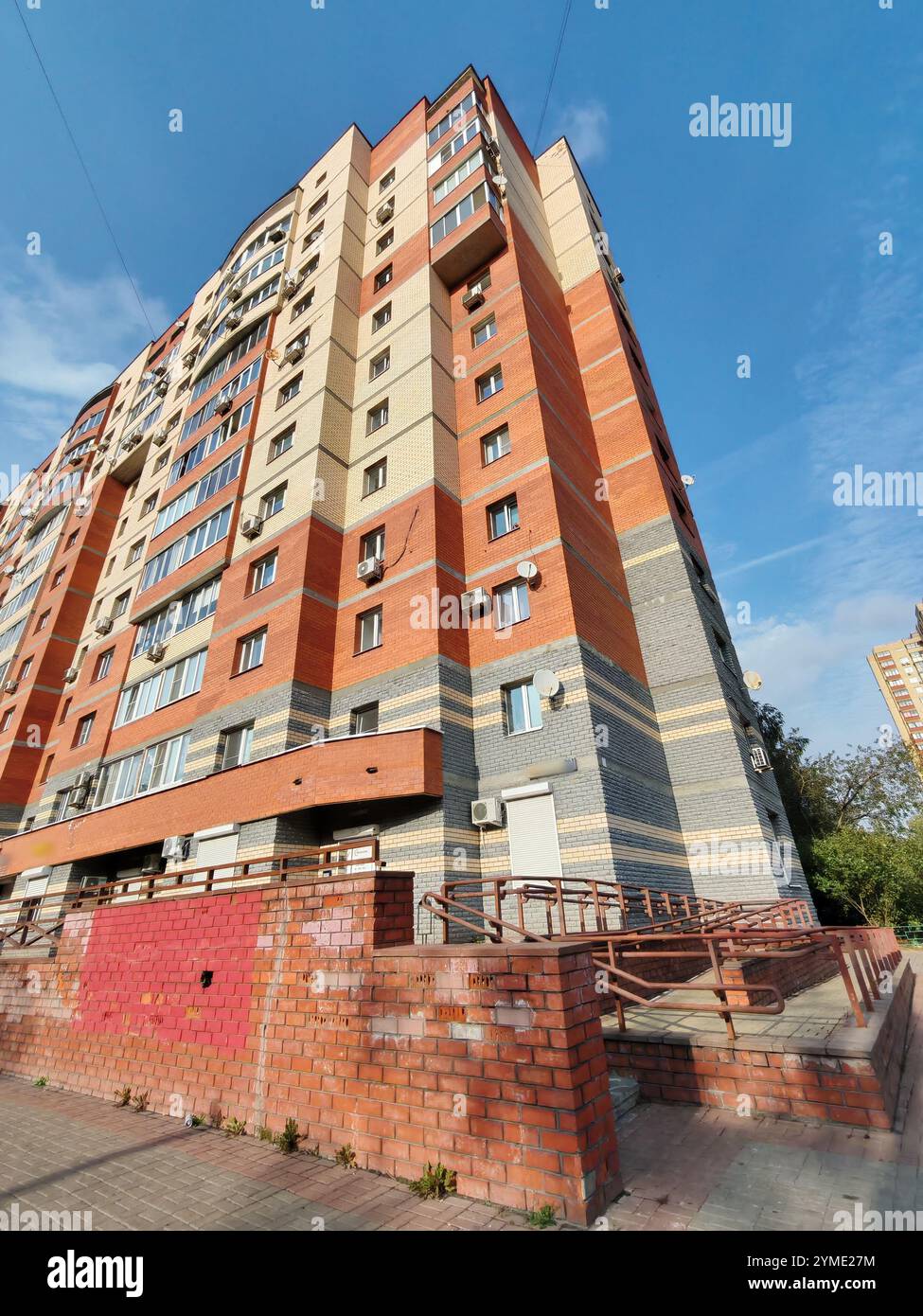 A high-rise residential building featuring a mix of red and beige brick ...