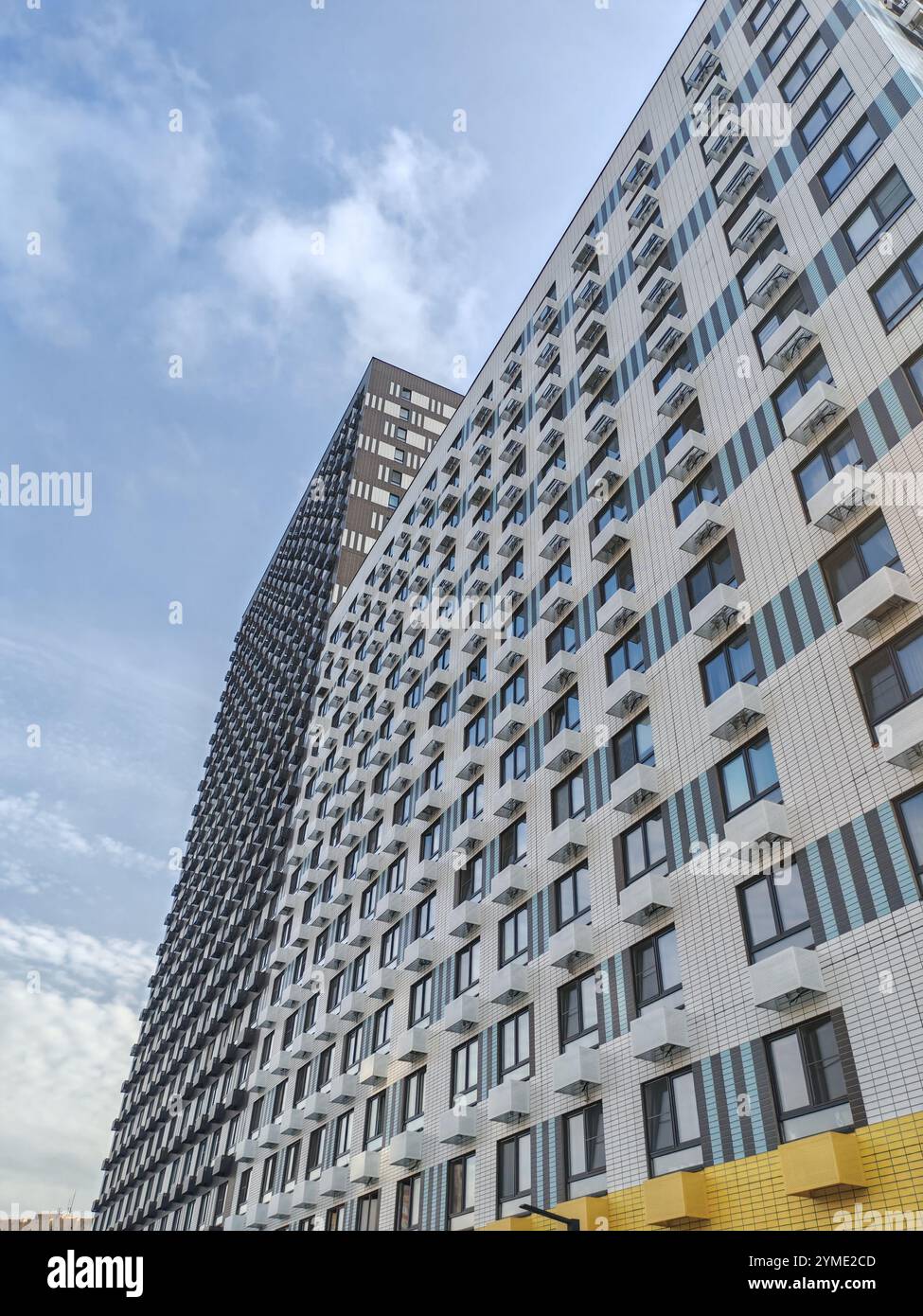 Two high-rise buildings featuring a dynamic contrast of yellow and ...
